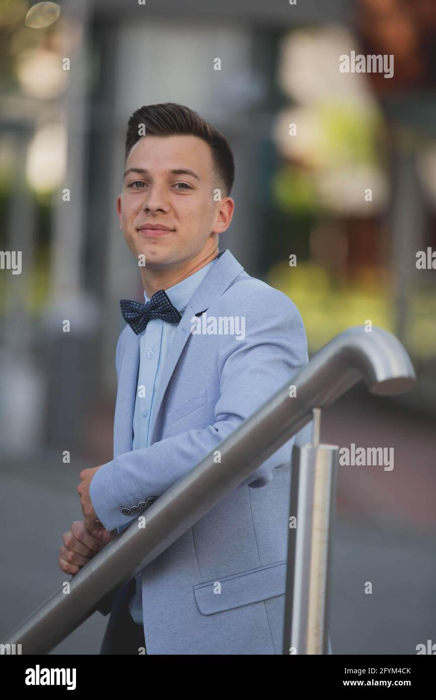 Vertical shot of a young male model posing in a light blue suit and a ...