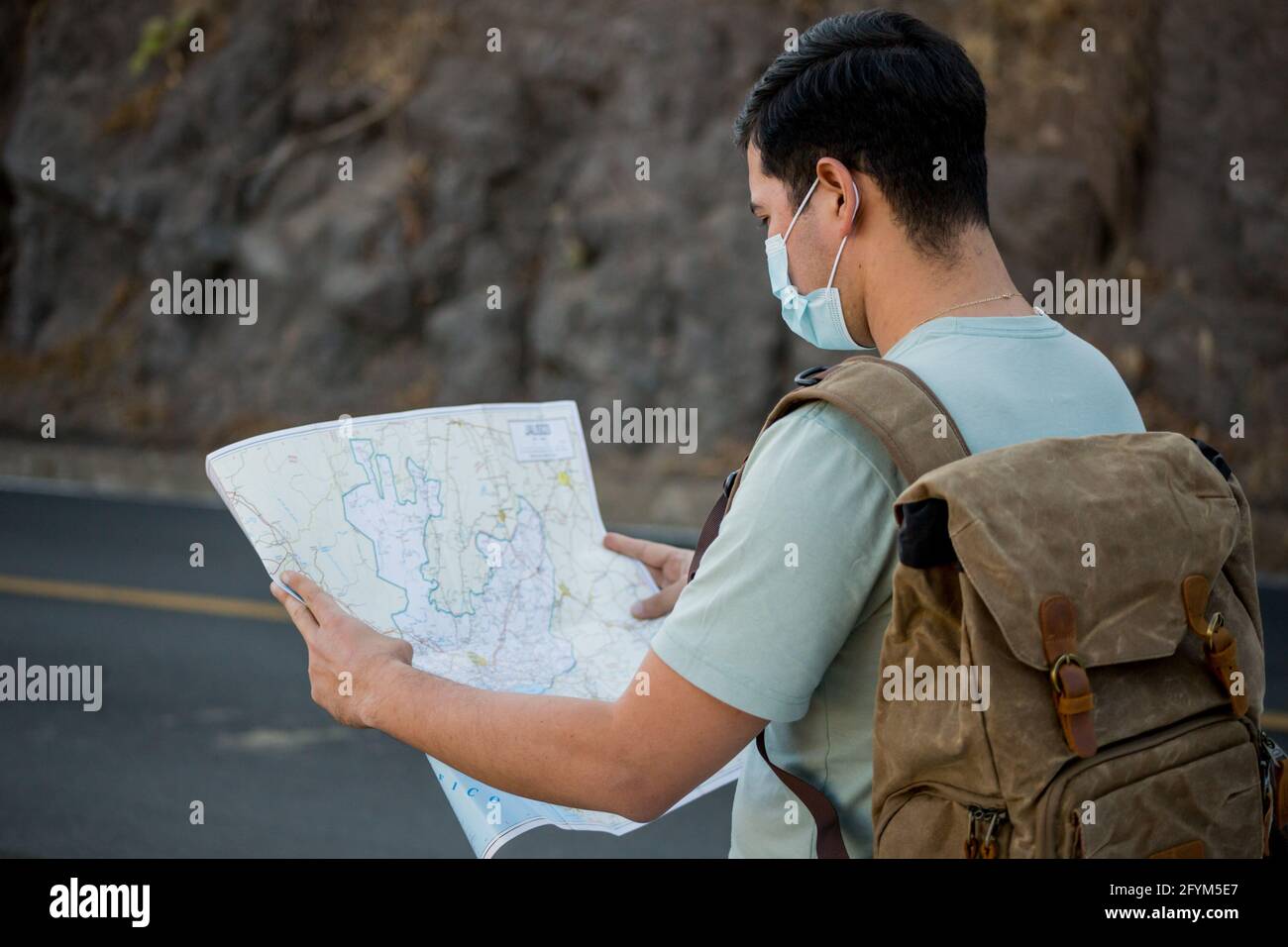 Man with mask with map in hand Stock Photo - Alamy