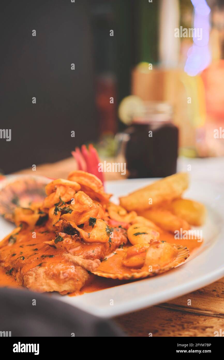 Peruvian food: Peruvian Dish a lo macho fish, wooden table, served on a ...