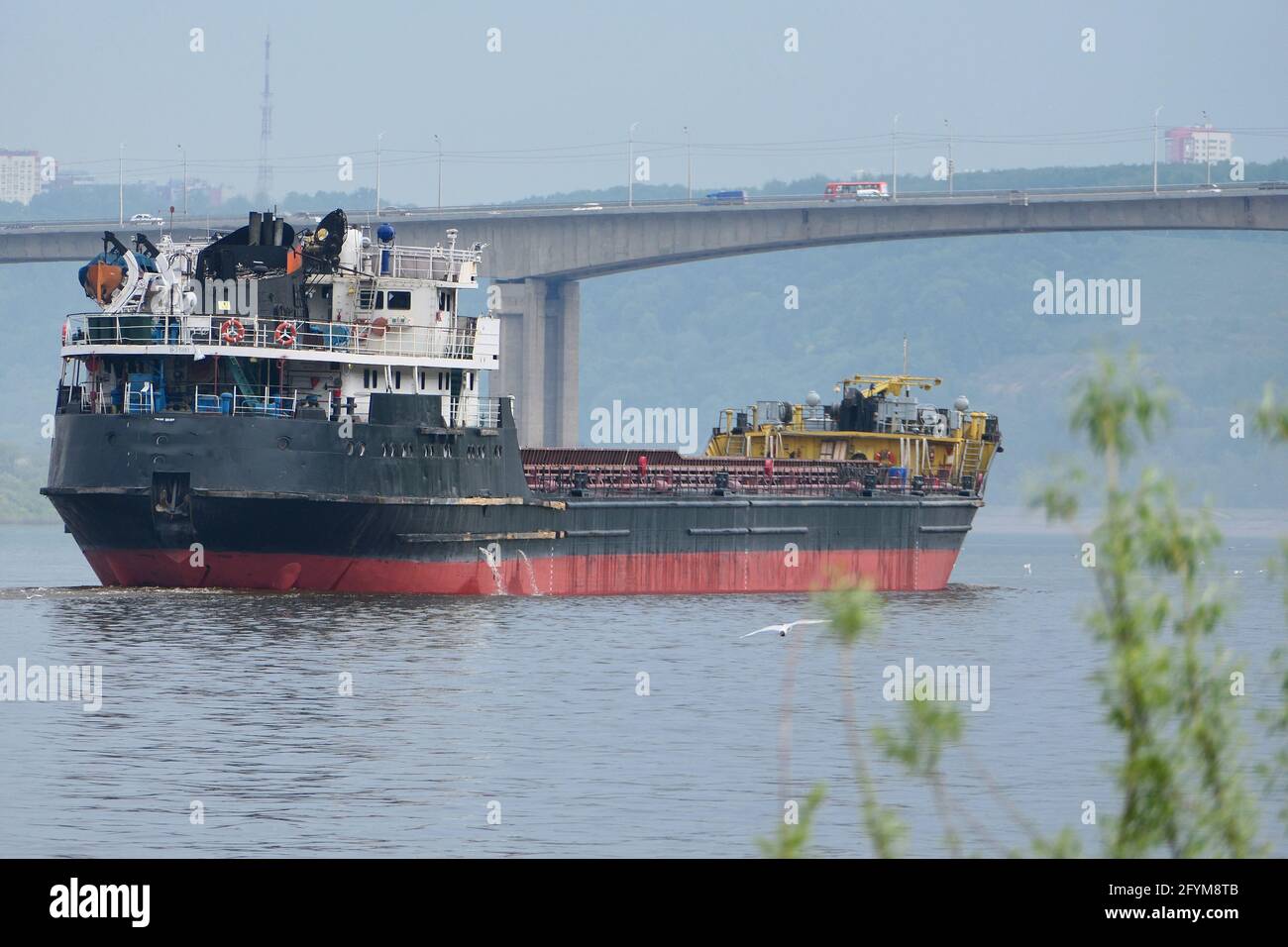 Cargo ship, a large ship is on the river, the passage under the bridge ...