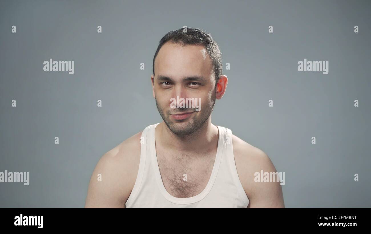 Photo of young bristly grinning man on grey Stock Photo - Alamy