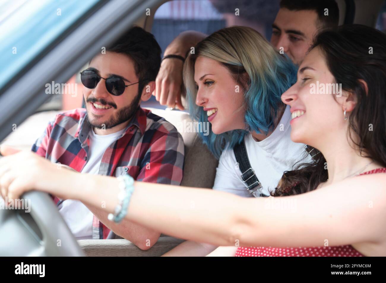 Group of friends travel together driving a car and making fun. Summer ...