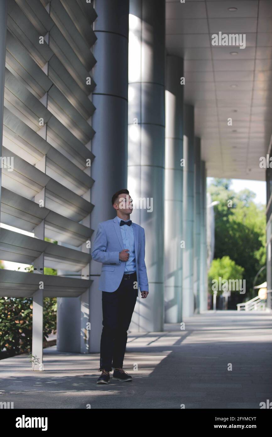 Vertical shot of a young male model posing in a light blue suit and a ...