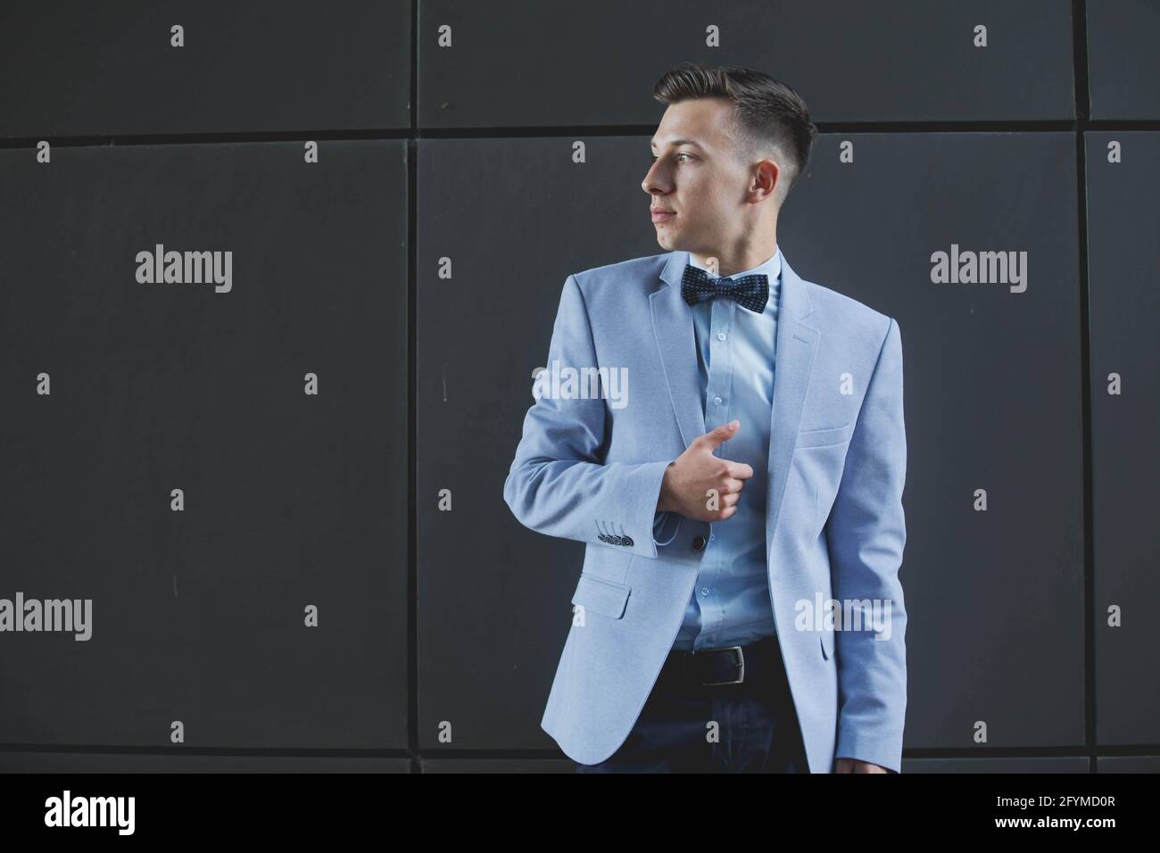 Young elegant Caucasian man wearing an expensive blue suit at an event ...