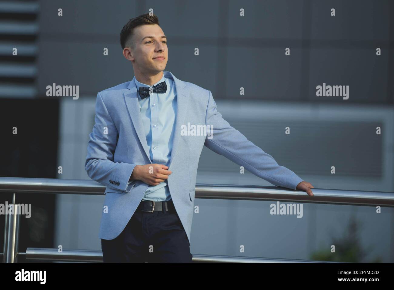 Young male model posing in a light blue suit and a bow tie Stock Photo ...