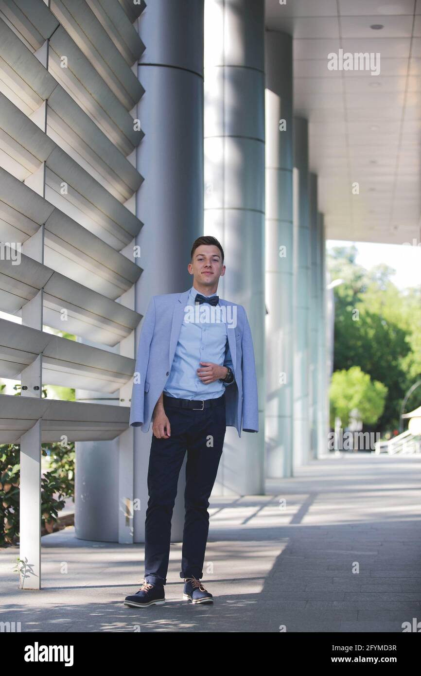 Vertical shot of a young male model posing in a light blue suit and a ...