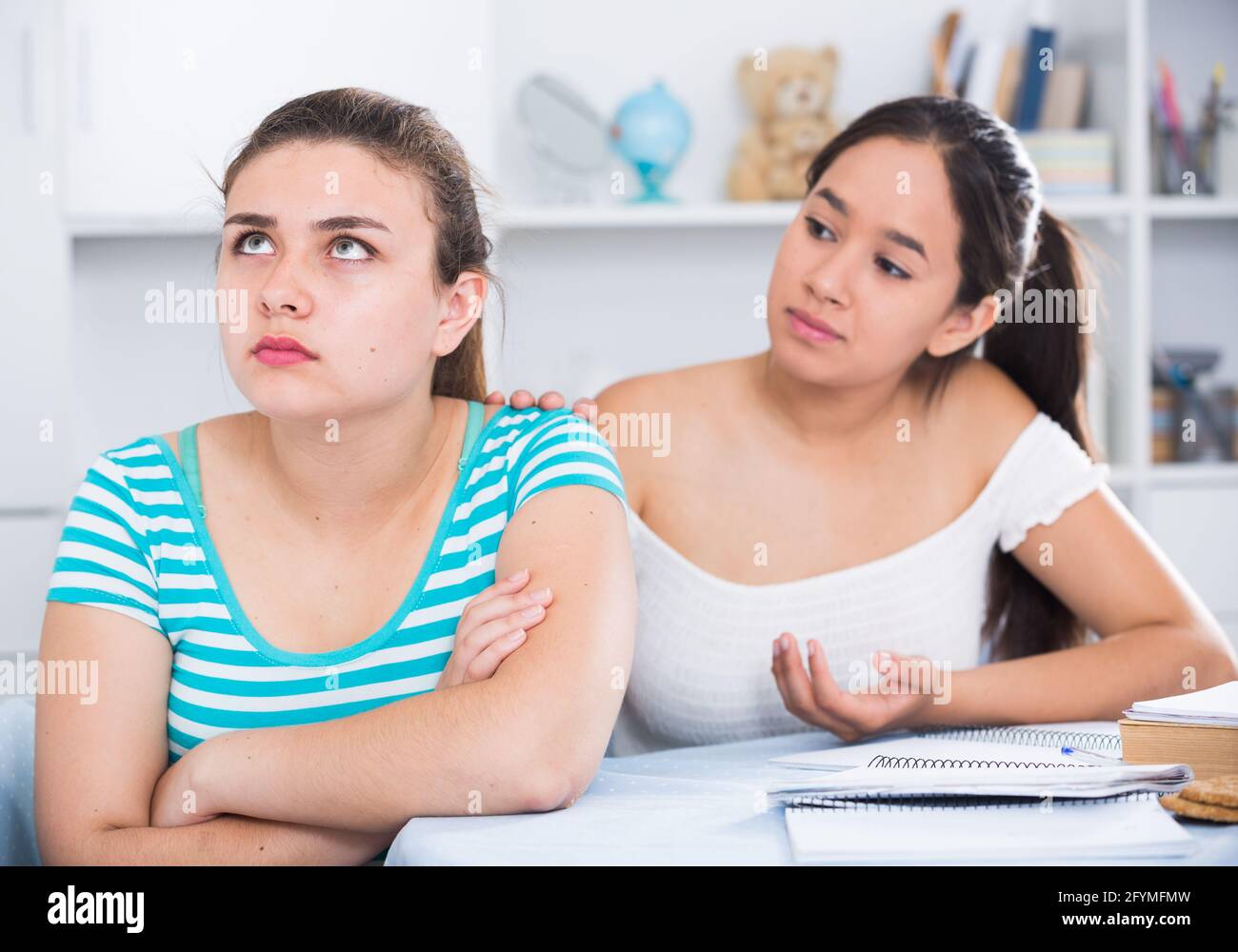 Teen girl trying to calm her female friend and apologize after dispute ...