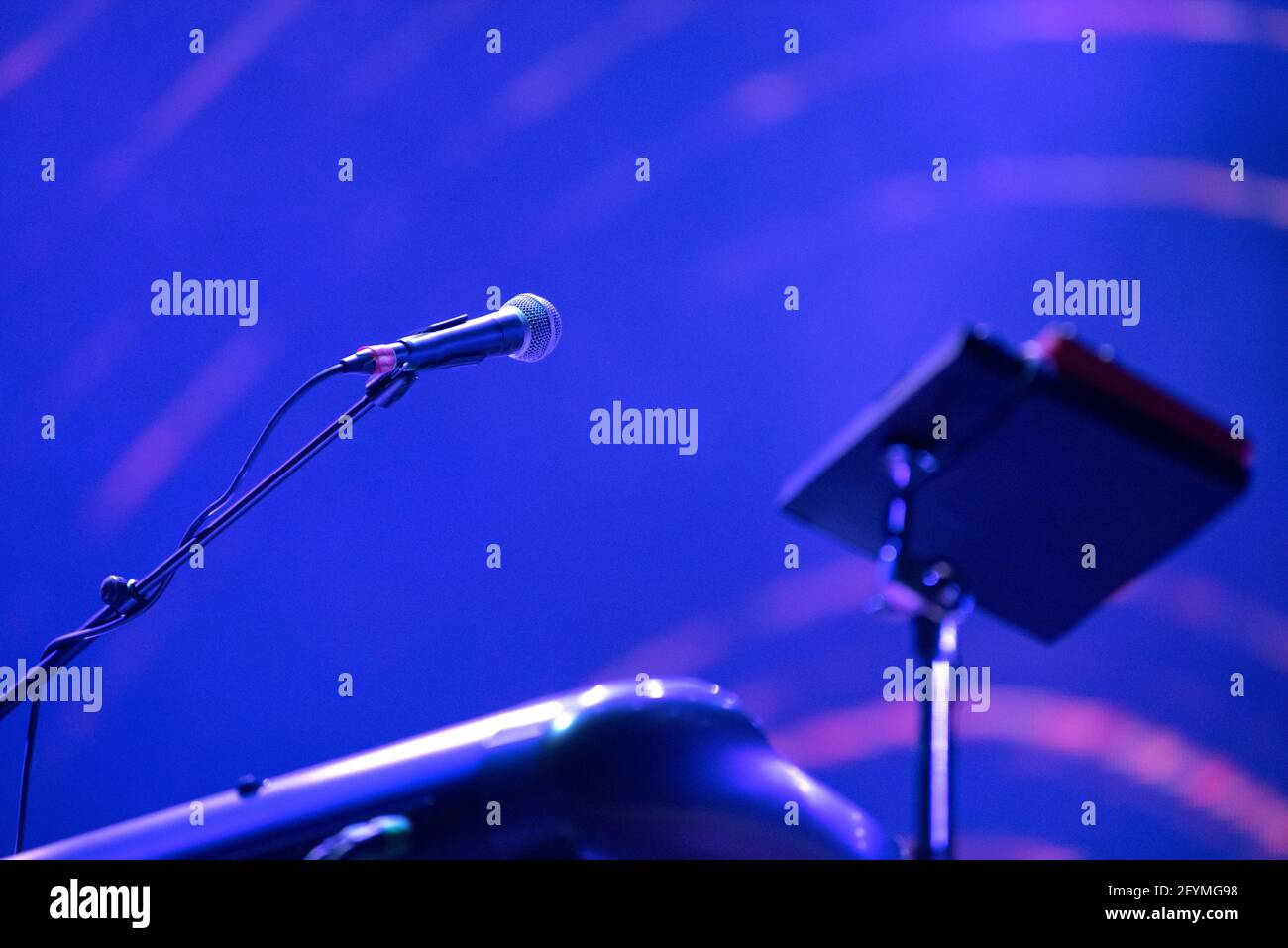 Microphone and music stand in blue stage lights at live concert Stock ...