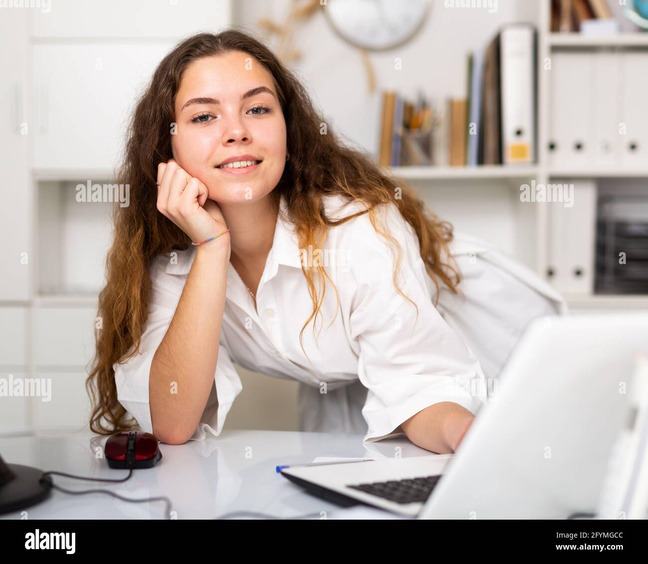 European girl journalist office employee working alone on laptop and ...