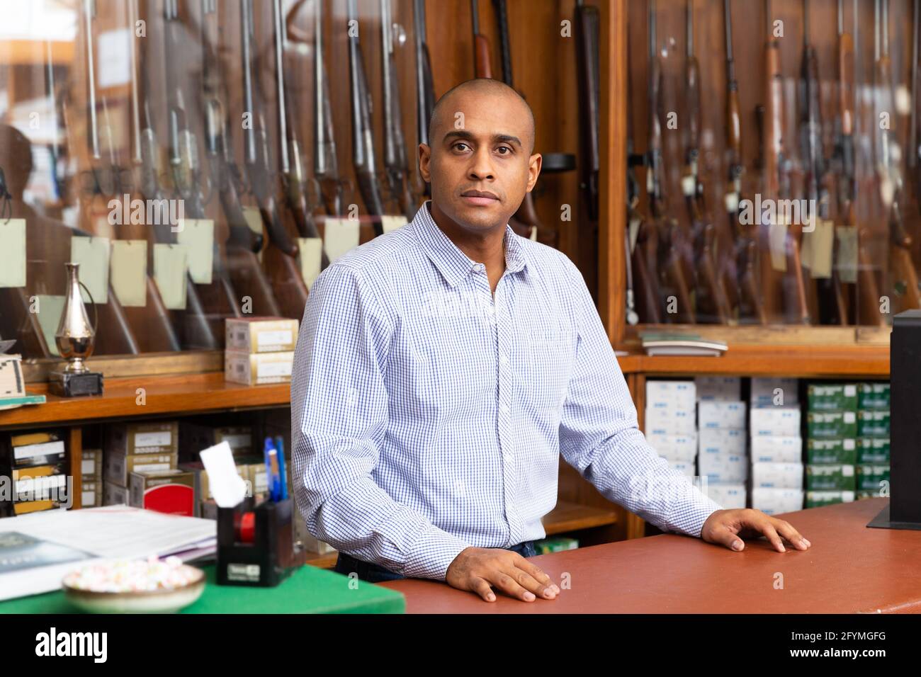 Portrait of confident latin american man owner of armory shop standing ...