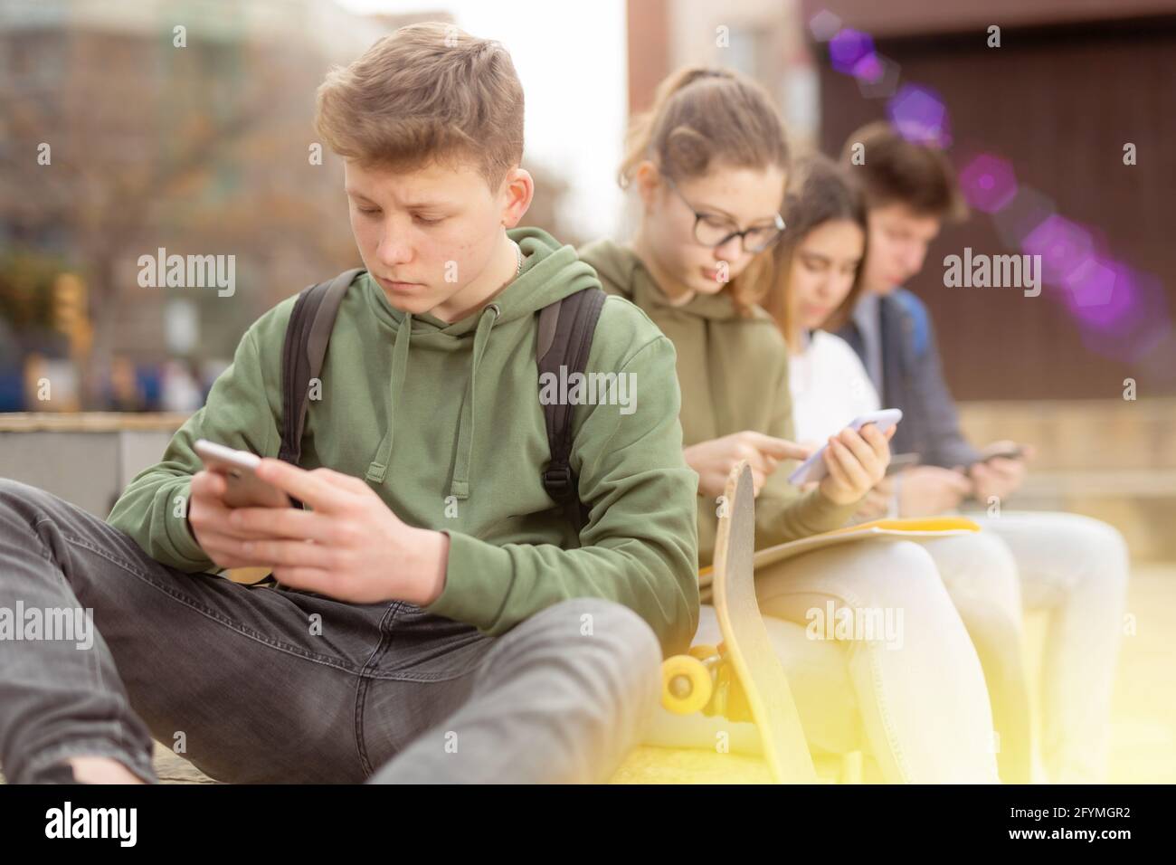 Four teenagers chatting on their smartphone on walking Stock Photo - Alamy