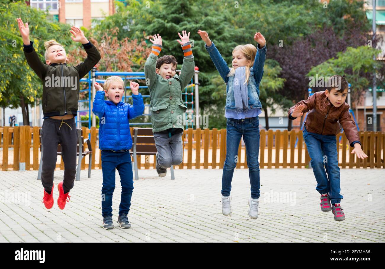 Happy kids jump and play outside Stock Photo - Alamy