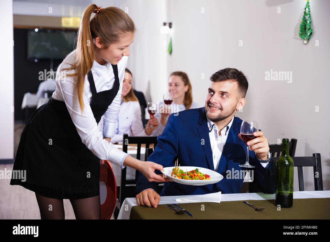 Woman waiter is giving dish to client in restaurante indoor Stock Photo ...