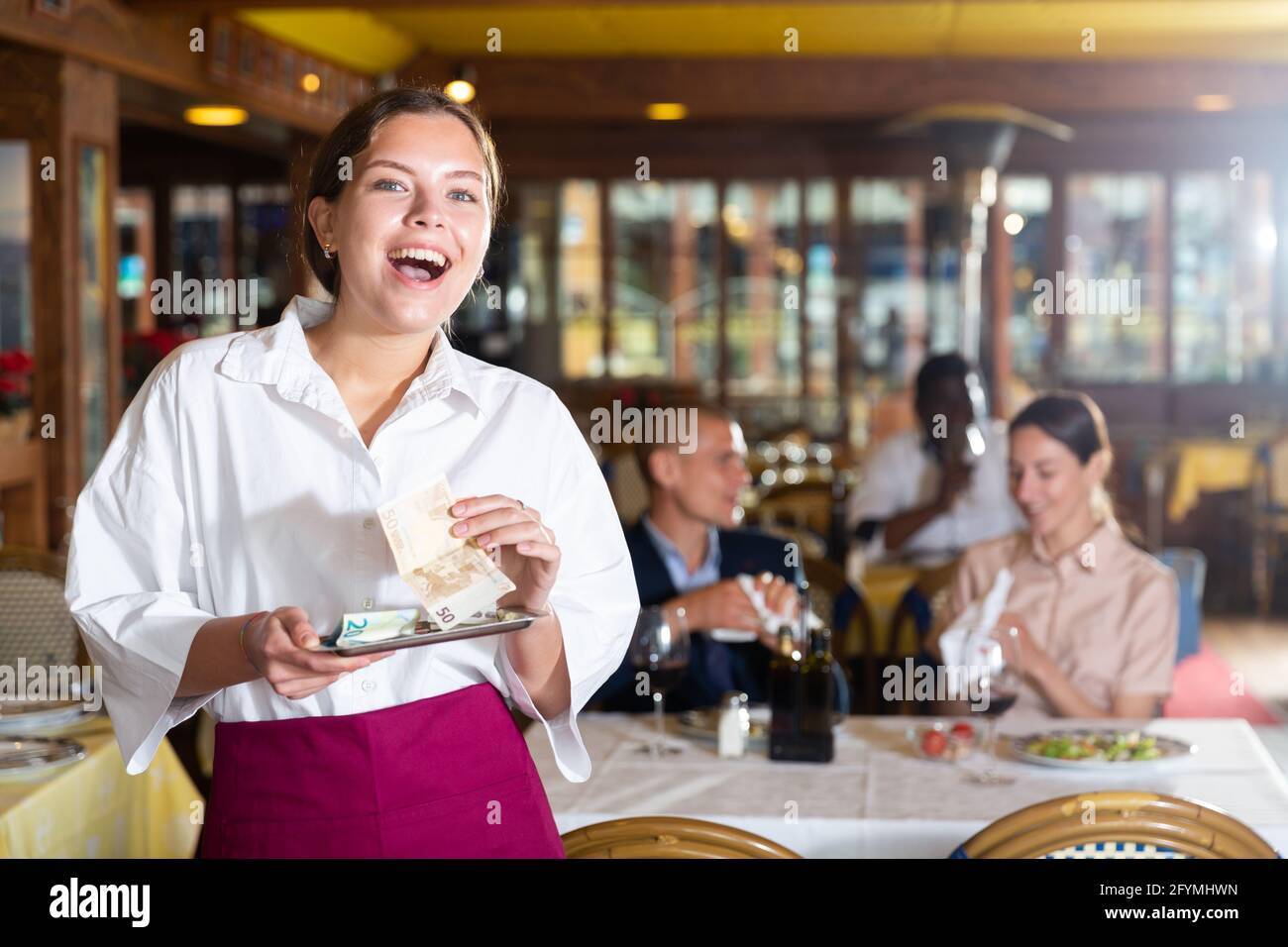 Happy waiter got a good tip from restaurant patrons Stock Photo - Alamy