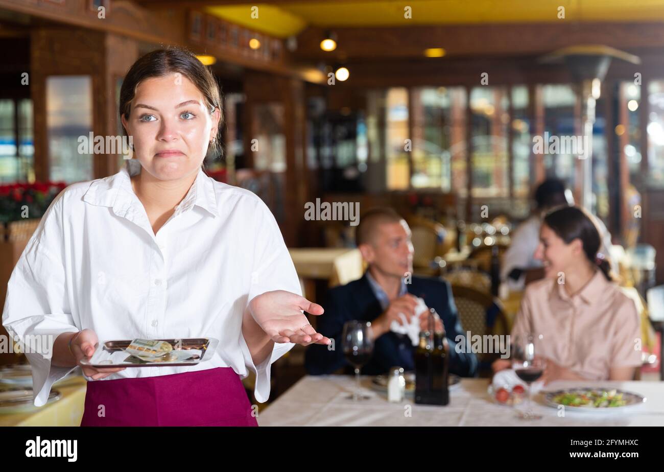 Portrait of upset waitress disappointed in small tip from guests at ...