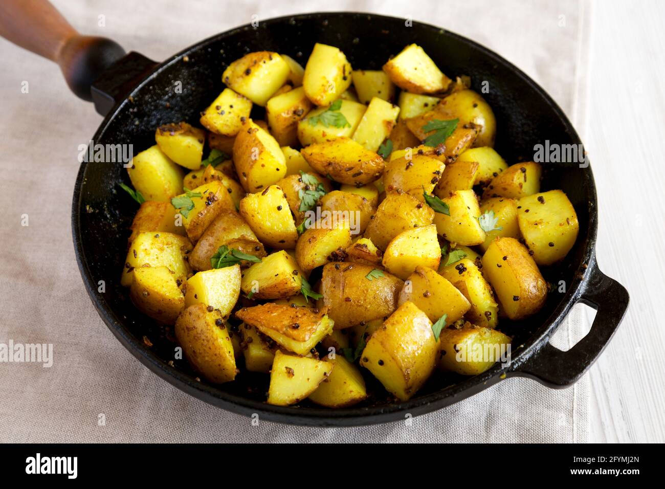 Homemade Roasted Potatoes with Mustard Seeds in a cast-iron pan, low ...