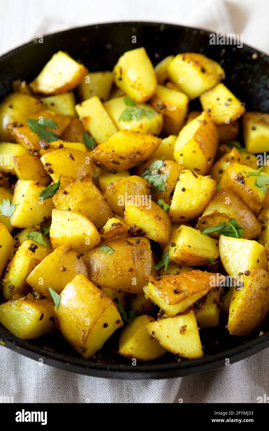 Homemade Roasted Potatoes with Mustard Seeds in a cast-iron pan, side ...