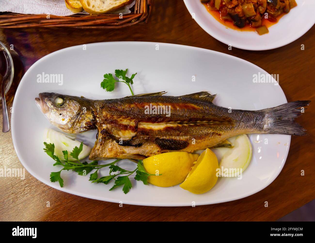 Tasty sea bass with onion, lemon and parsley. Turkish cuisine Stock ...