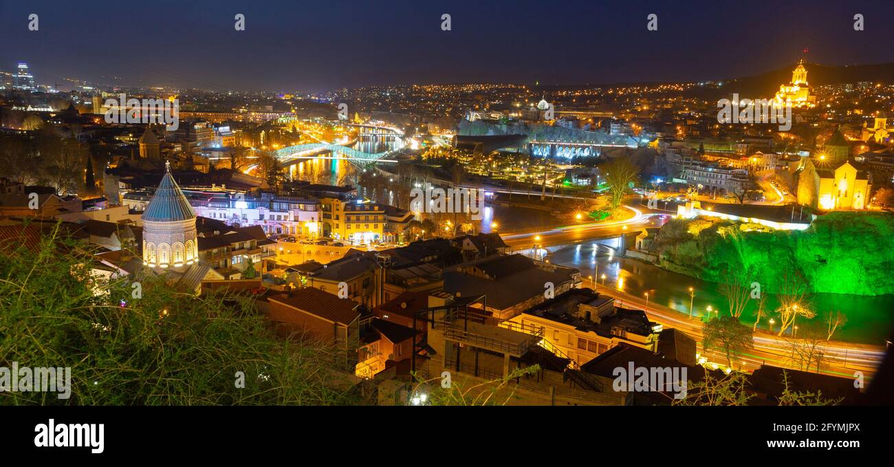 Scenic cityscape of town Tbilisi with illuminated buildings and bridges ...