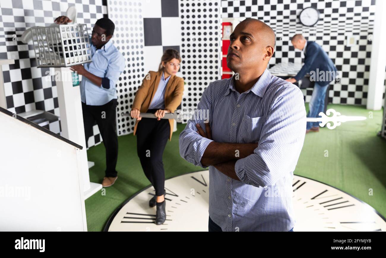 Man looking for way out of quest room with his business colleagues ...