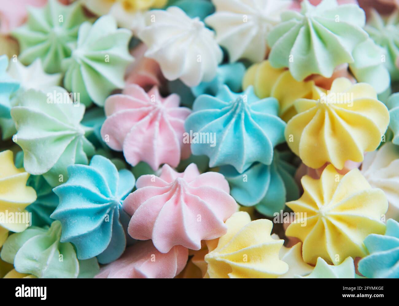 Close-up delicious meringue cookies pastel colors background. French ...