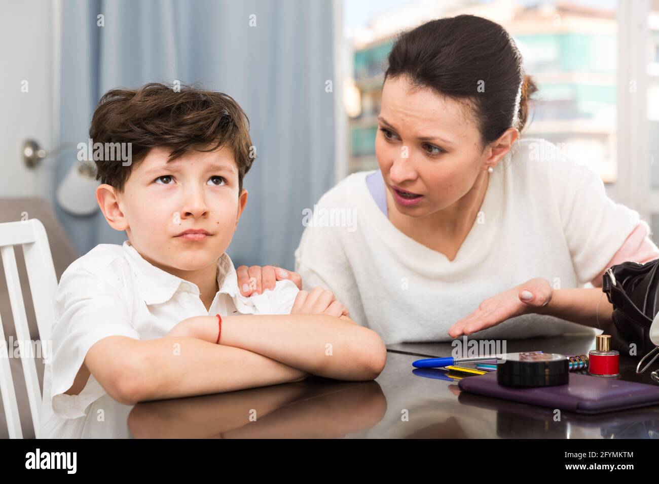 Portrait of troubled teen boy and his mother scolding him in home ...