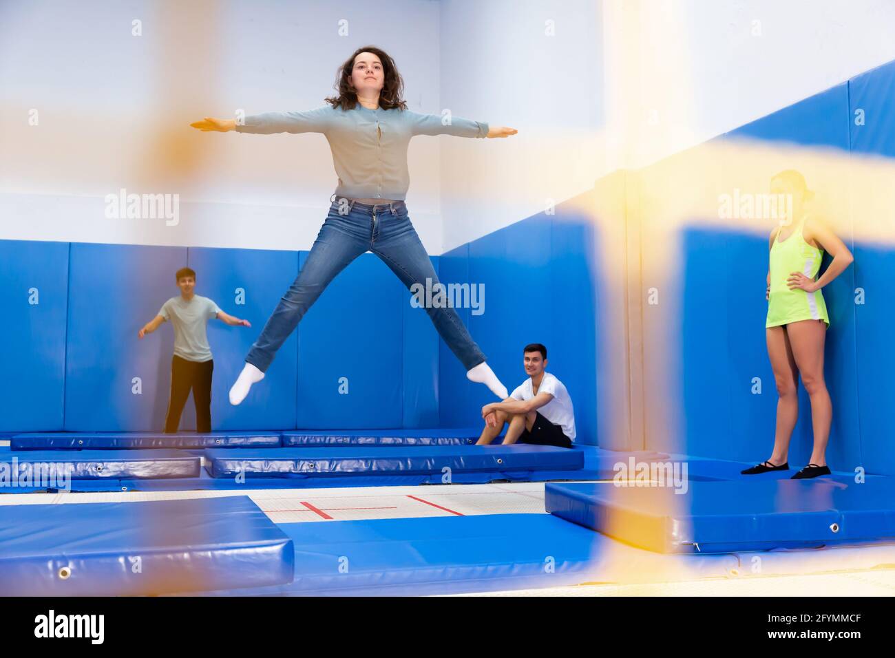 View through yellow safety net of sporty woman with friends practicing ...