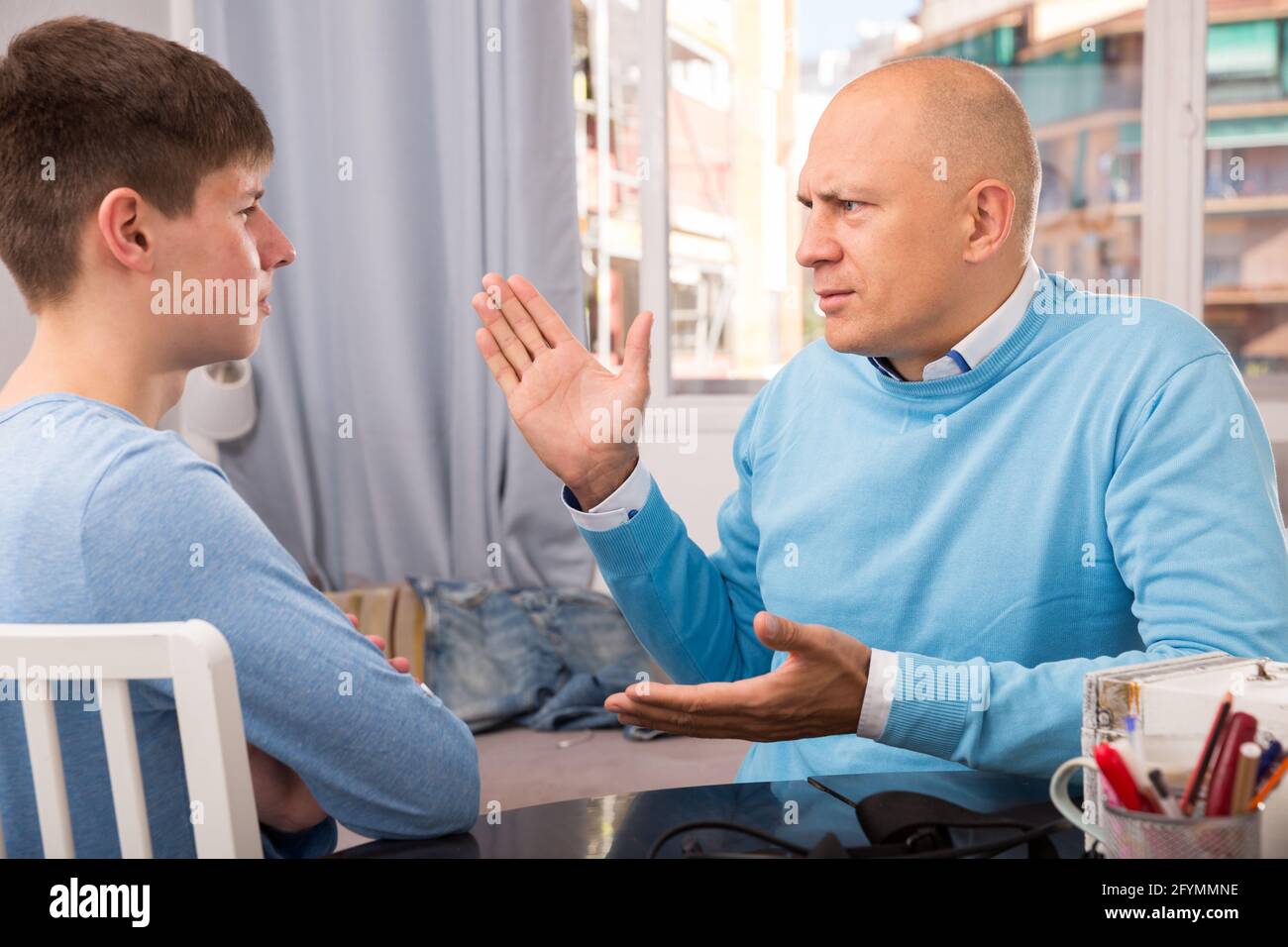 Unhappy man lecturing his teenage son at home interior Stock Photo - Alamy