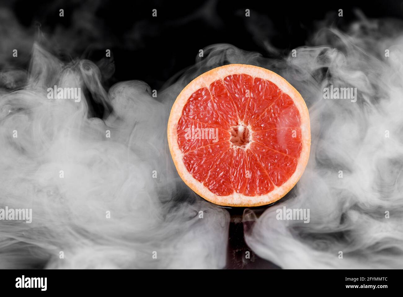 Grapefruit with smoke on black background. Citrus fruit with smoke of ...