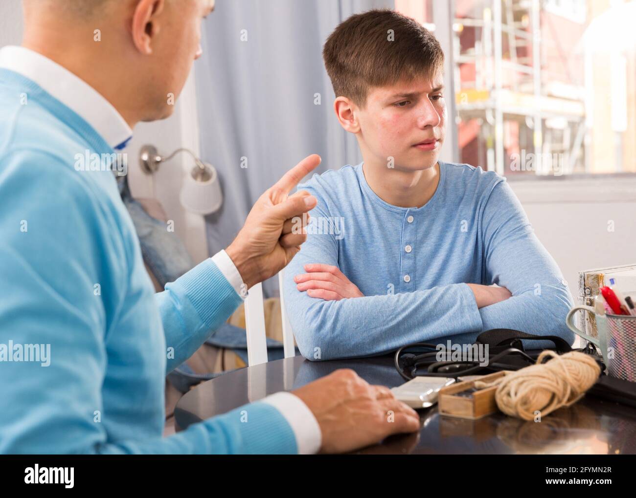 Unhappy man lecturing his teenage son at home interior Stock Photo - Alamy