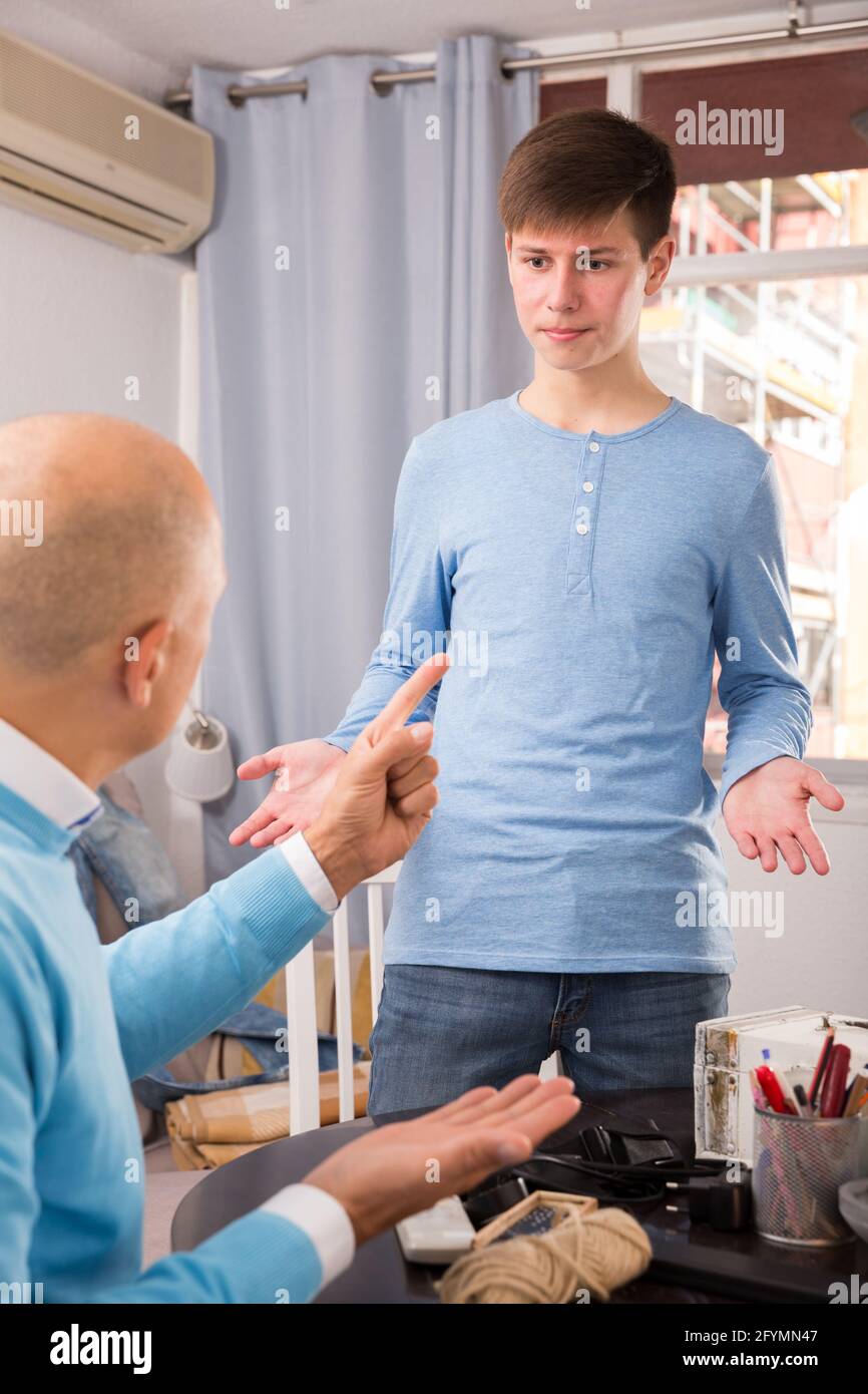 Unhappy man lecturing his teenage son at home interior Stock Photo - Alamy
