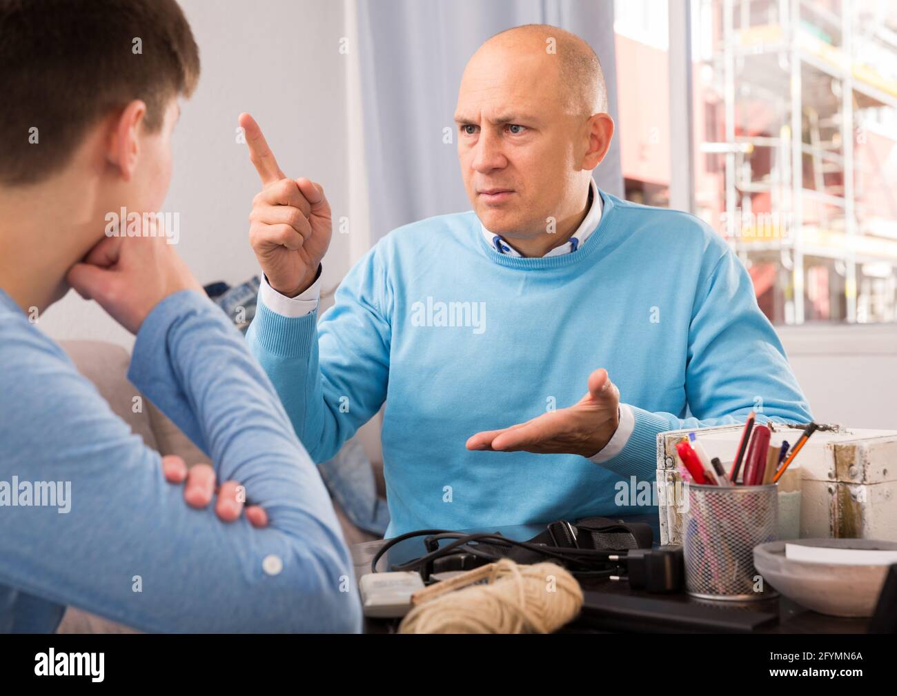 Strict father having serious conversation with teen boy at home Stock ...