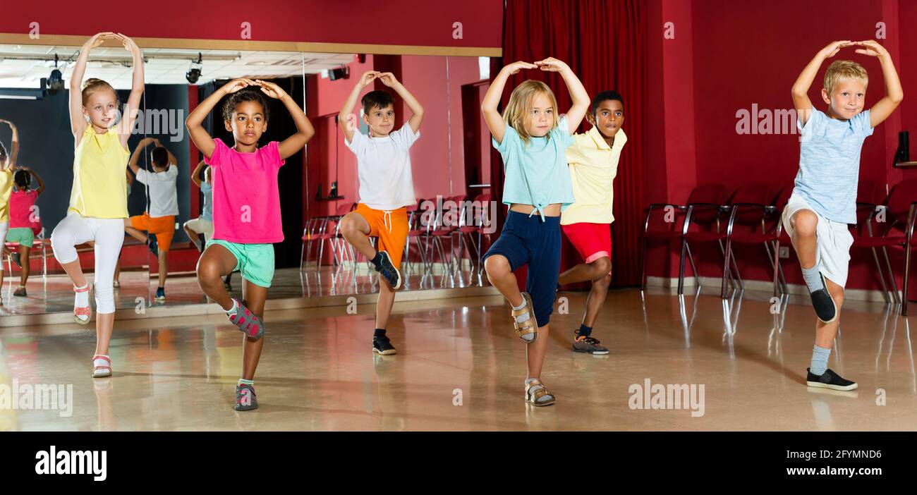 Group of positive childrens trying balance movements of ballet at a ...
