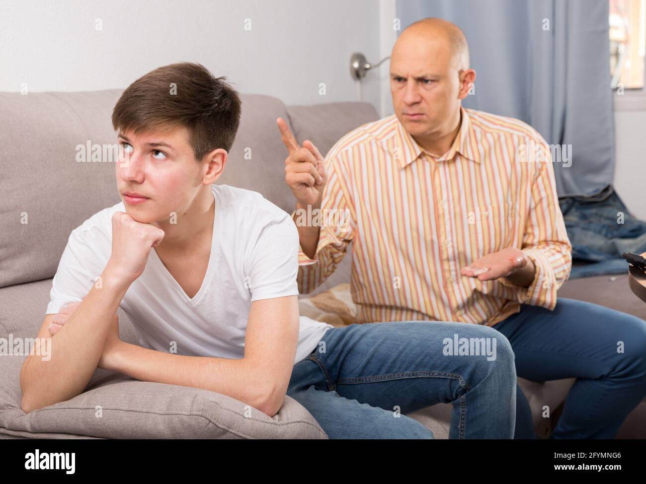 Unhappy man scolding his teenage son at home interior Stock Photo - Alamy
