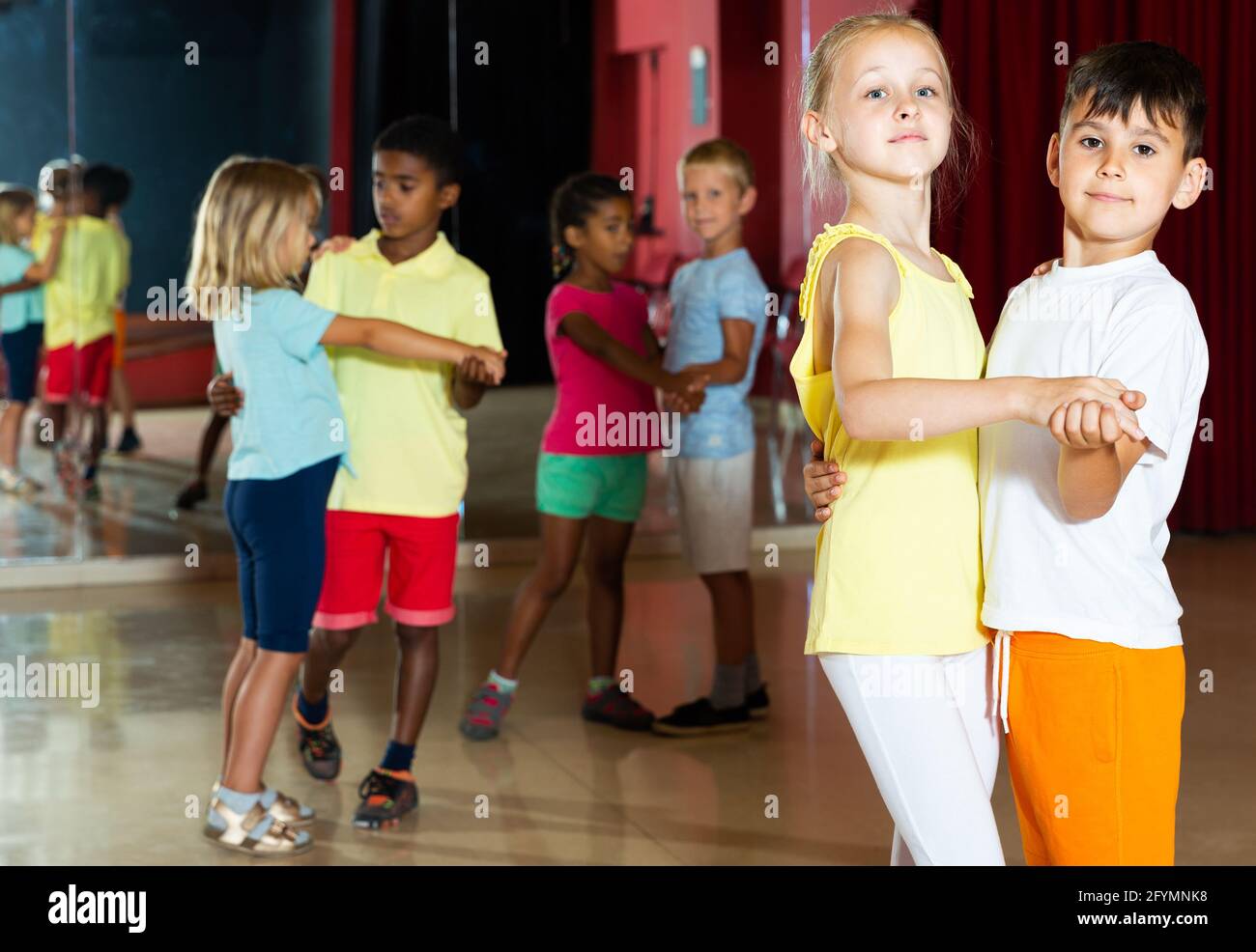 Smiling kids primary school trying dancing of partner dance in modern ...