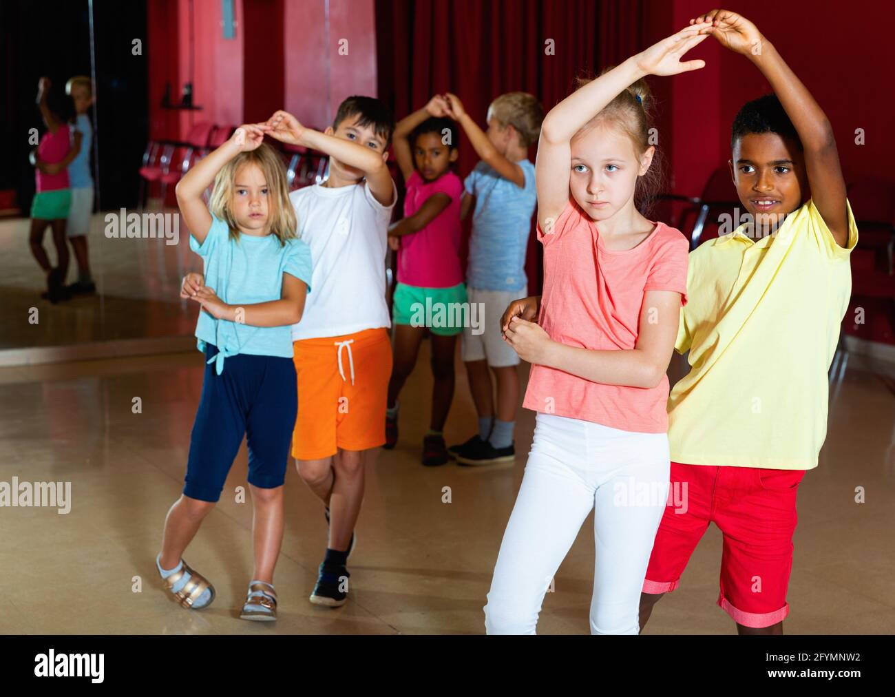 Smiling happy cheerful positive children primary school trying dancing ...