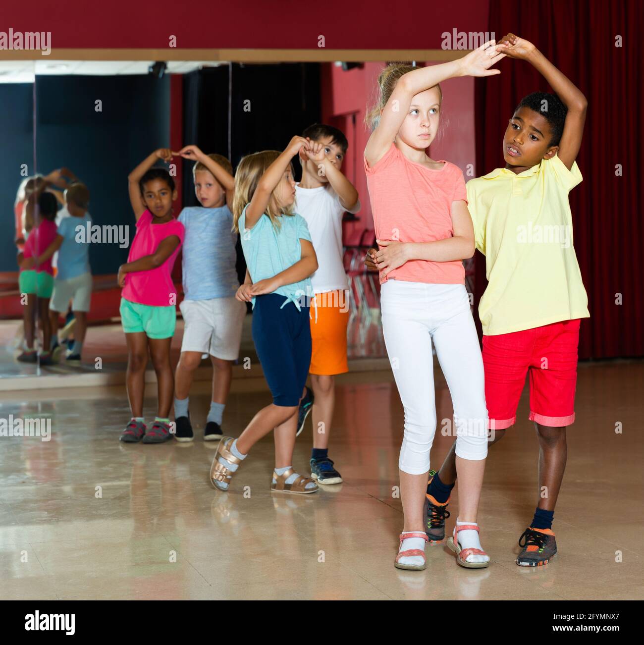 Group of joyful kids dancing salsa dance in modern studio Stock Photo ...
