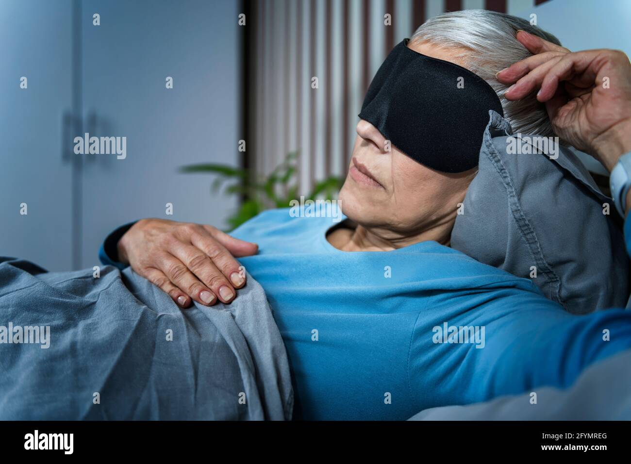 Mature woman wearing black sleep mask Stock Photo - Alamy