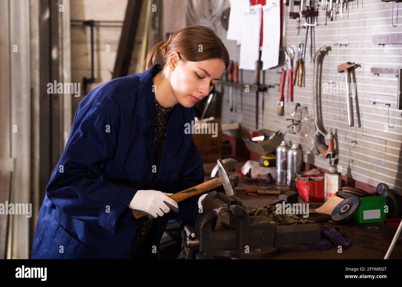 Young woman handles part on bench vise Stock Photo - Alamy