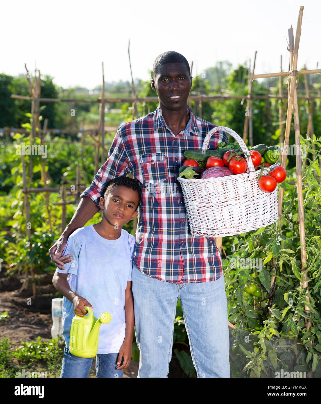 Happy family with harvest of vegetables in the garden Stock Photo - Alamy