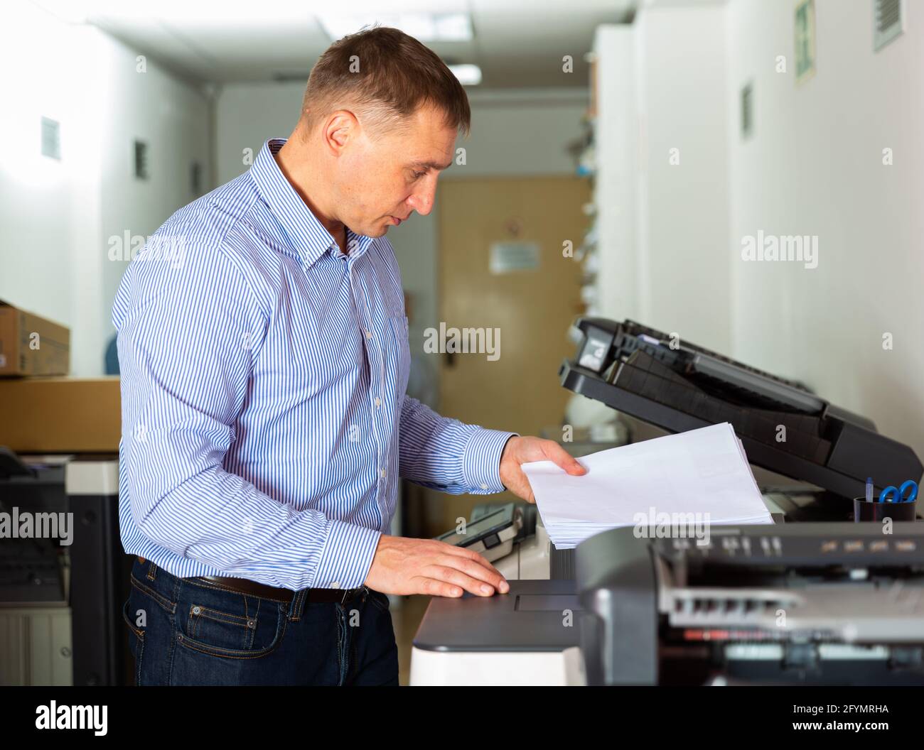 Office worker puts a stack of paper in the printer Stock Photo - Alamy