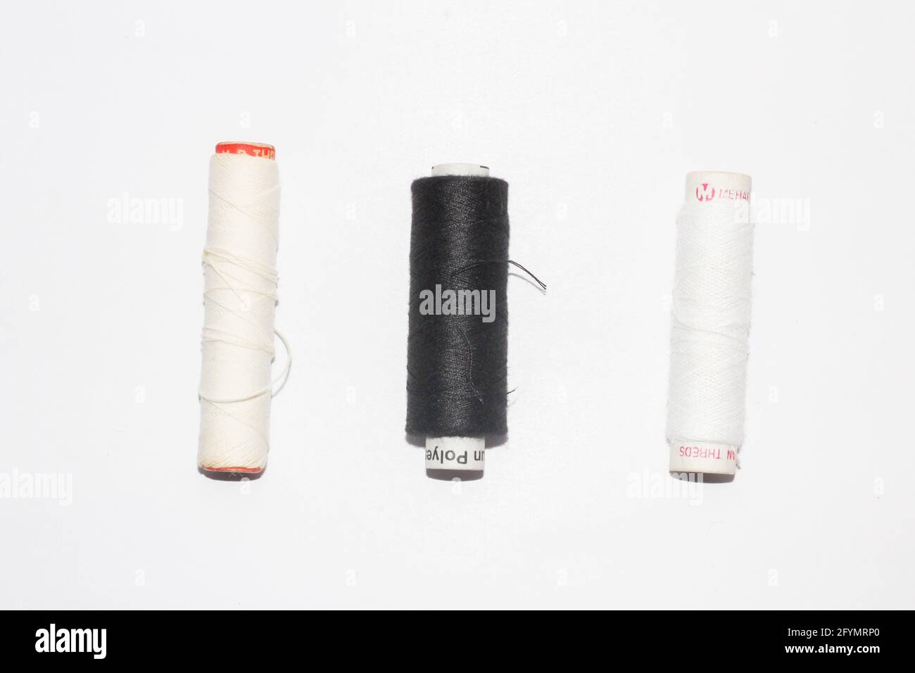 Closeup shot of black and white sewing threads isolated on a white ...
