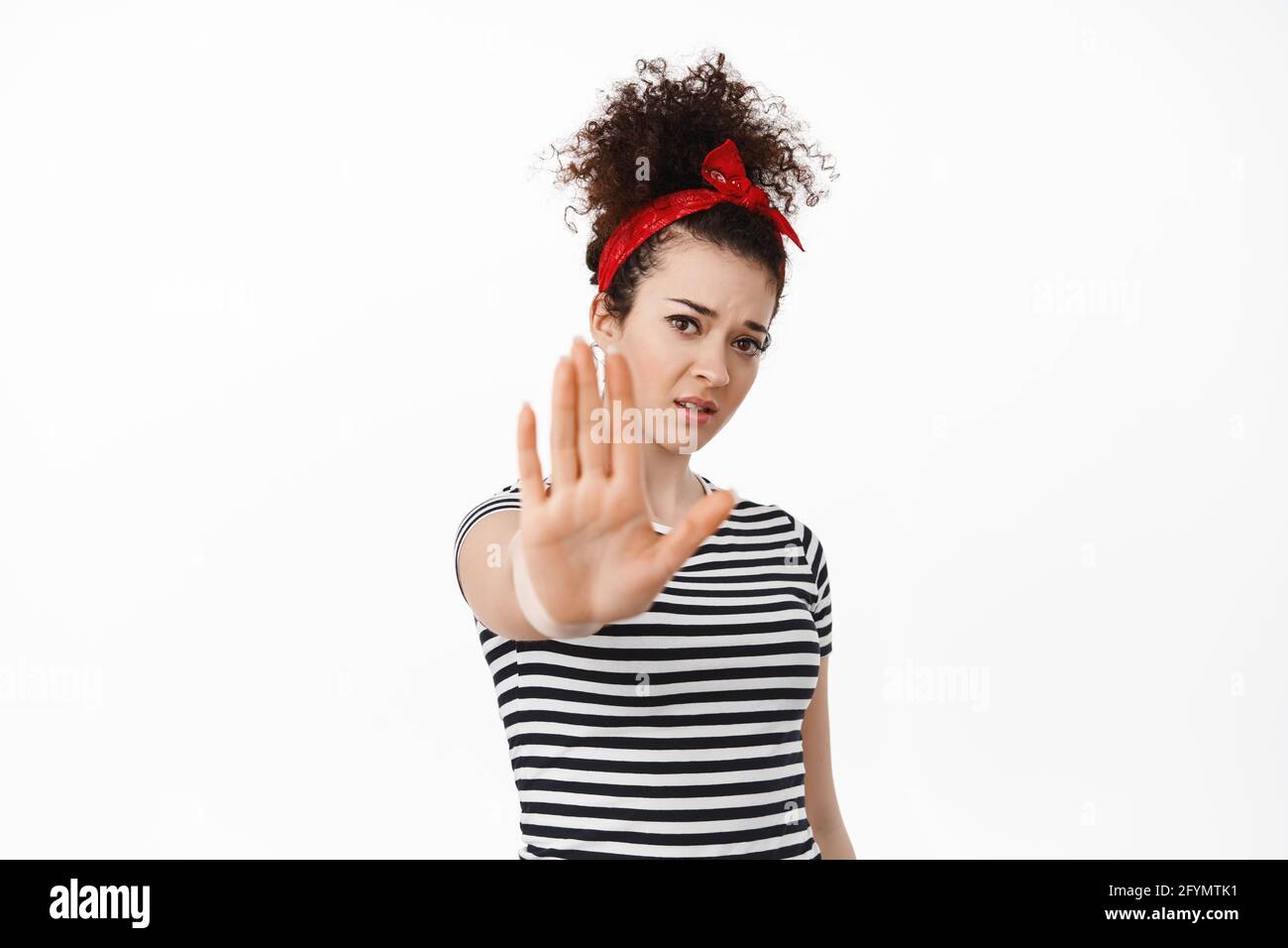 Stop it. Young brunette woman stretch hand and tell no, forbid ...