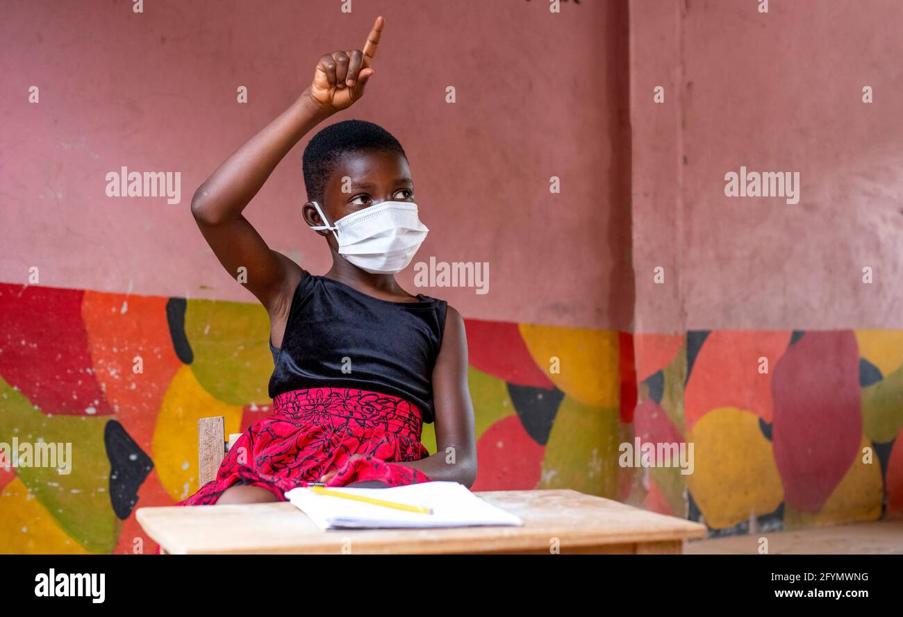 Girl raising her hand in class Stock Photo - Alamy