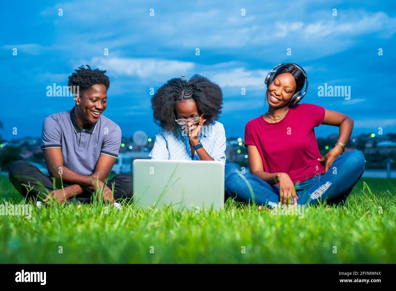 Friends using laptop computer Stock Photo - Alamy