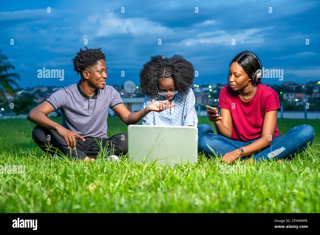Friends using laptop computer Stock Photo - Alamy