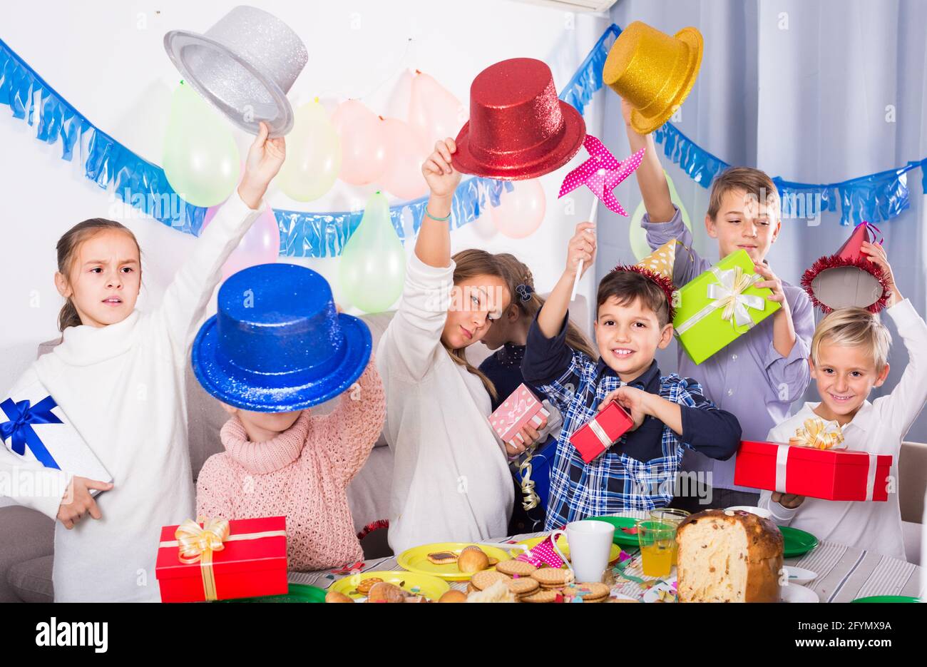 Group of little children exchanging gifts with each other during party ...