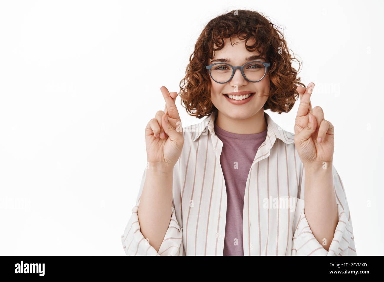 High hopes. Excited girl student making wish with fingers crossed ...