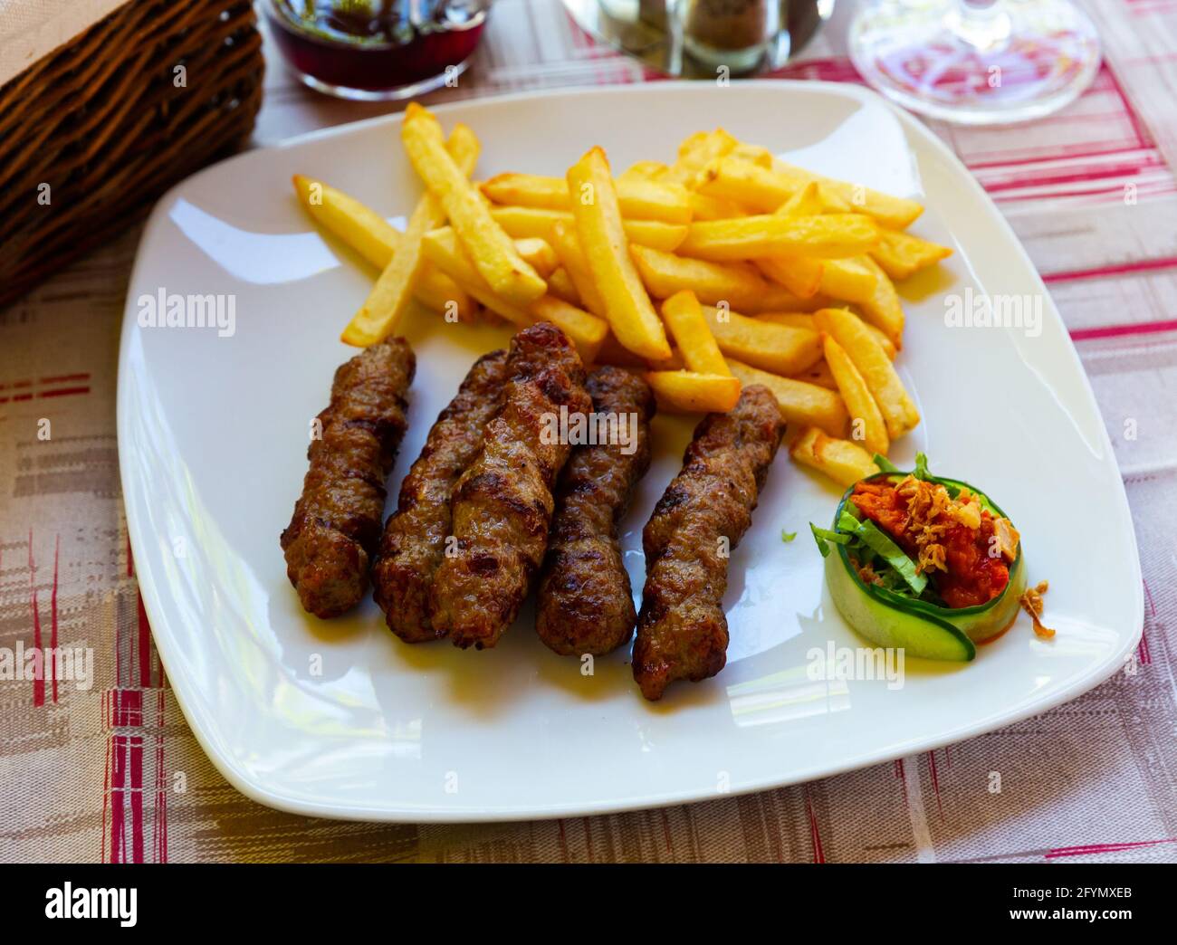 Delicious Balkan dish Cevapcici, grilled minced meat garnished with ...