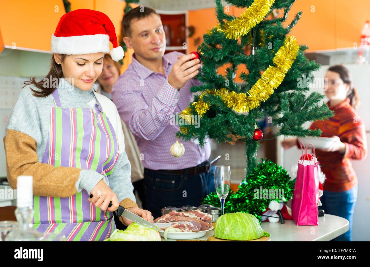 Young woman cooking food for christmas dinner at home, family ...